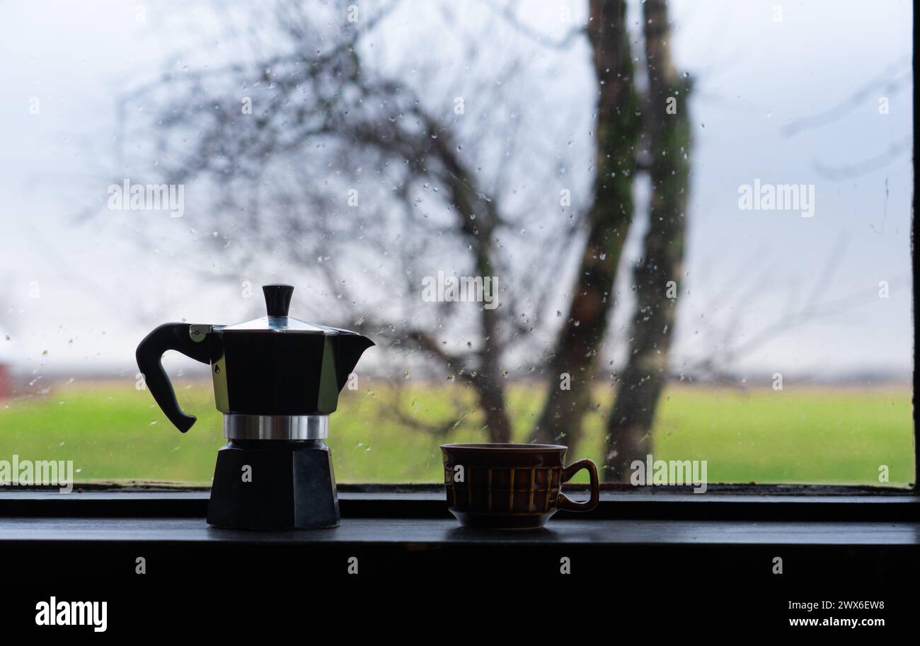 Cup of coffee and Italian coffee pot on a window on a rainy day Stock ...