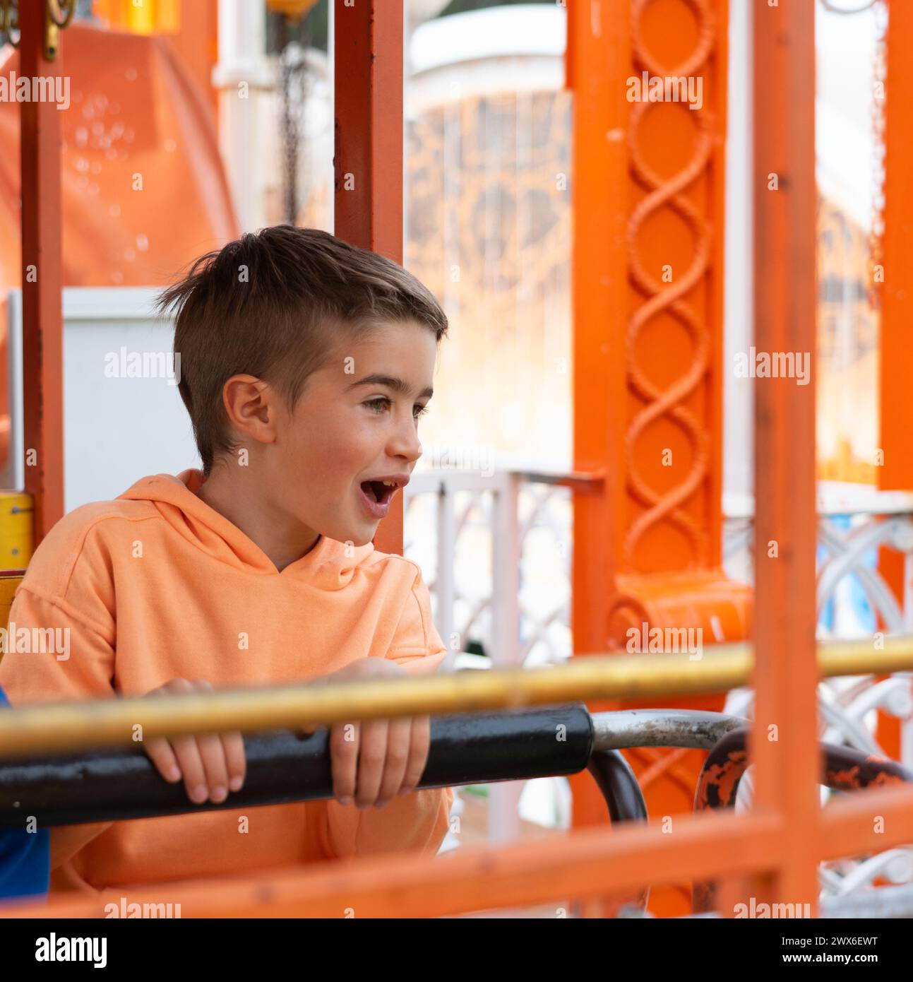 Boy riding a little train at an amusement park Stock Photo - Alamy