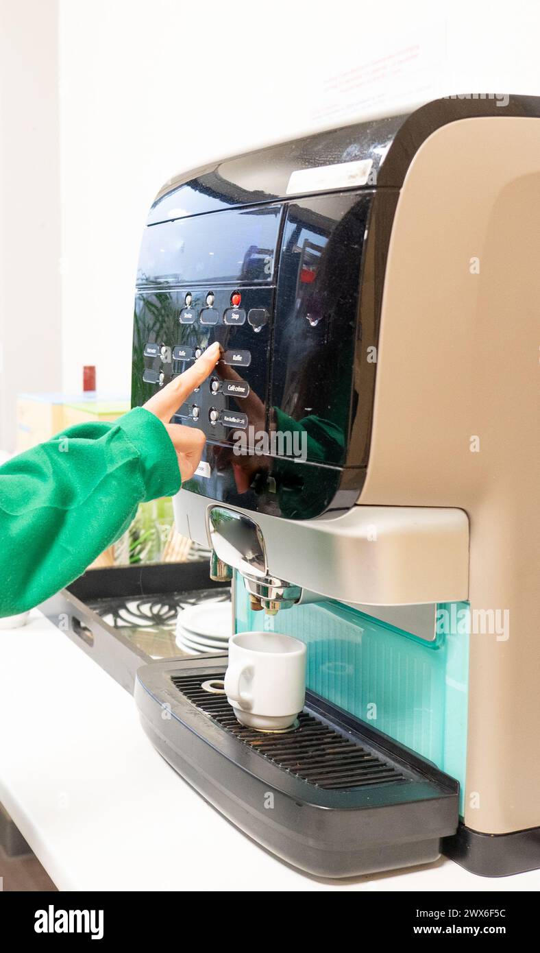 Coworking coffee machine with a hand selecting a type of coffee Stock ...