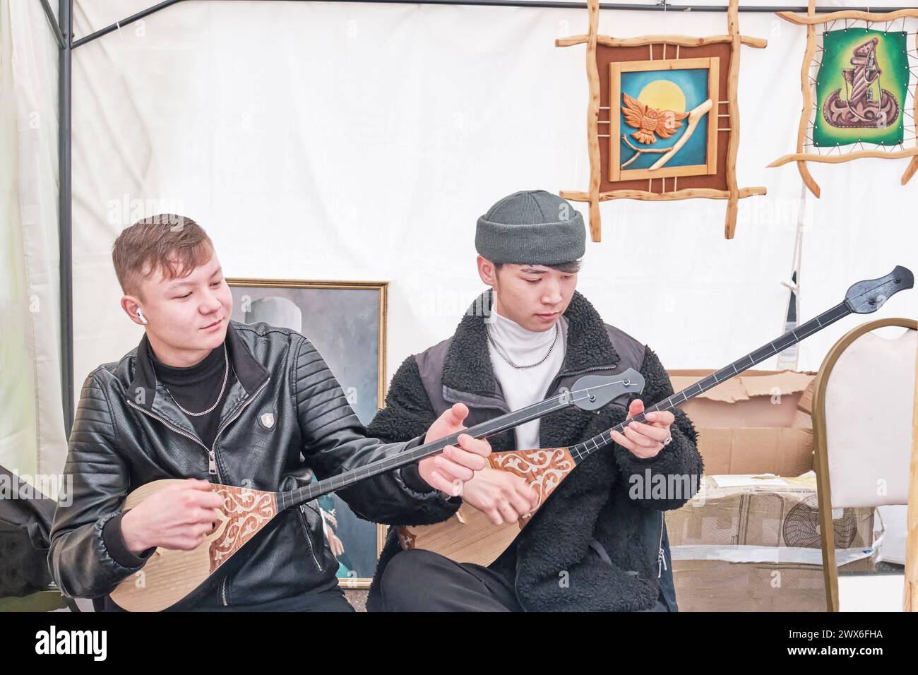 Almaty, Kazakhstan - March 21, 2024: Two boys teenagers play dombras in ...