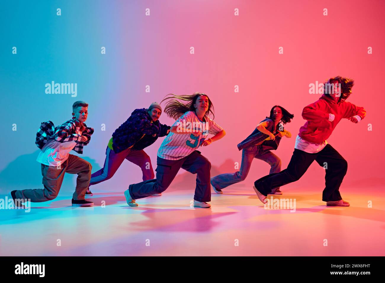 Casually dressed teenagers perform forward-moving dance sequence in ...