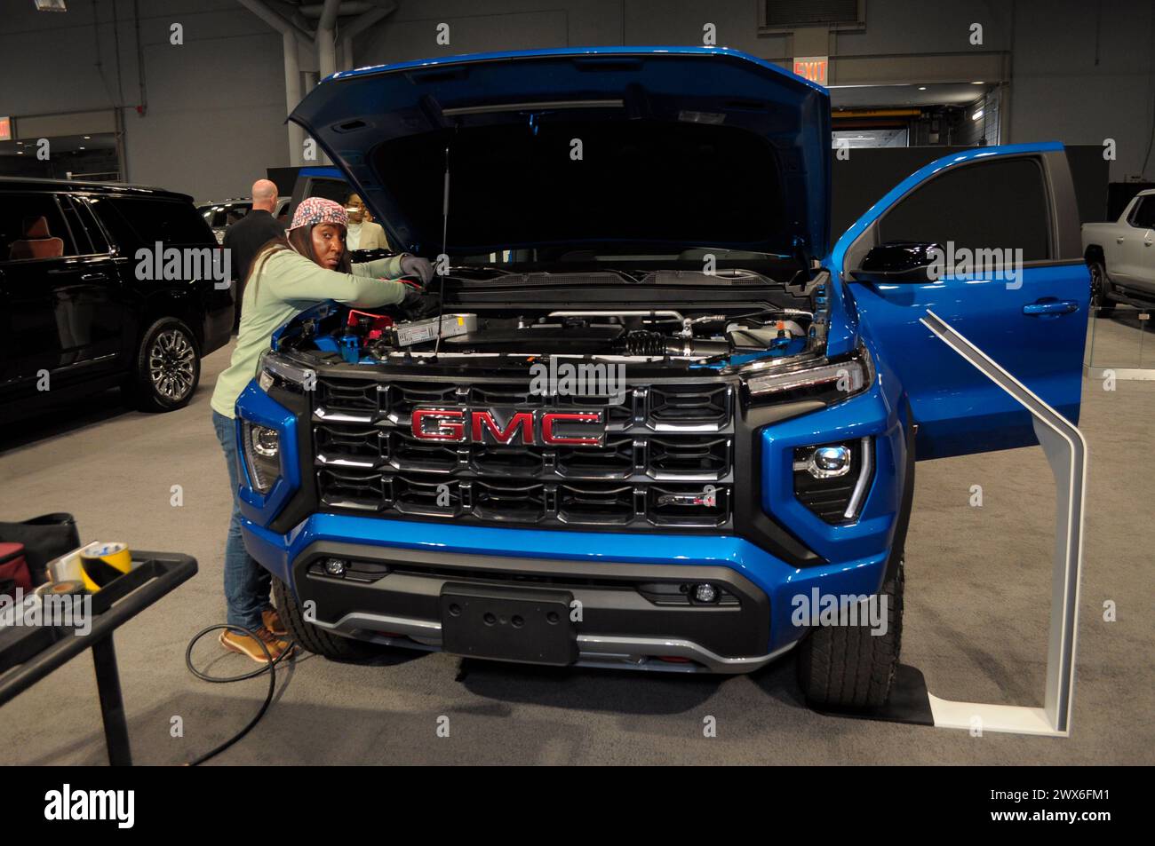 A person works under the hood of a GMC Canyon AT4 vehicle on the first ...