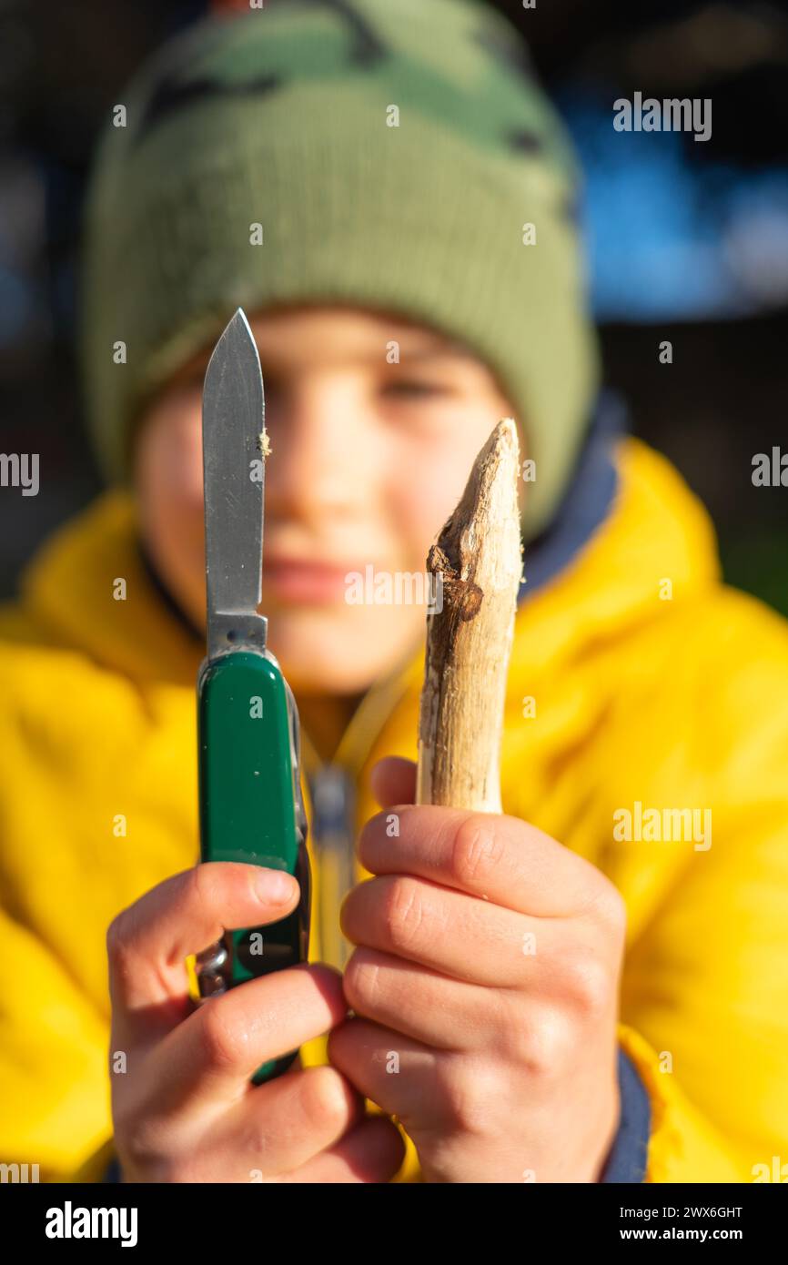 Boy showing a sharp stick and a knife Stock Photo - Alamy