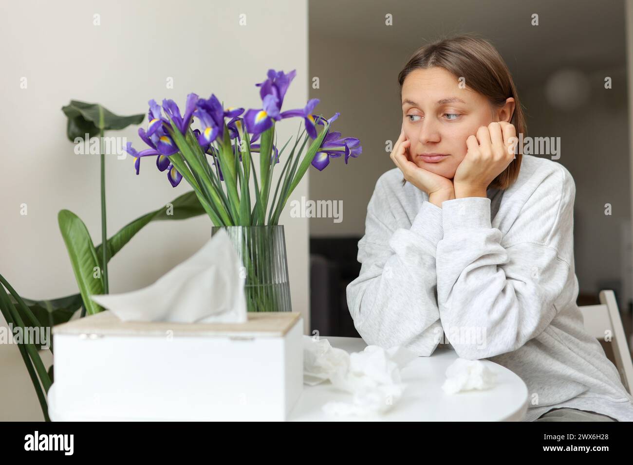 Seasonal allergy. Unhealthy allergic young woman uses paper tissues ...