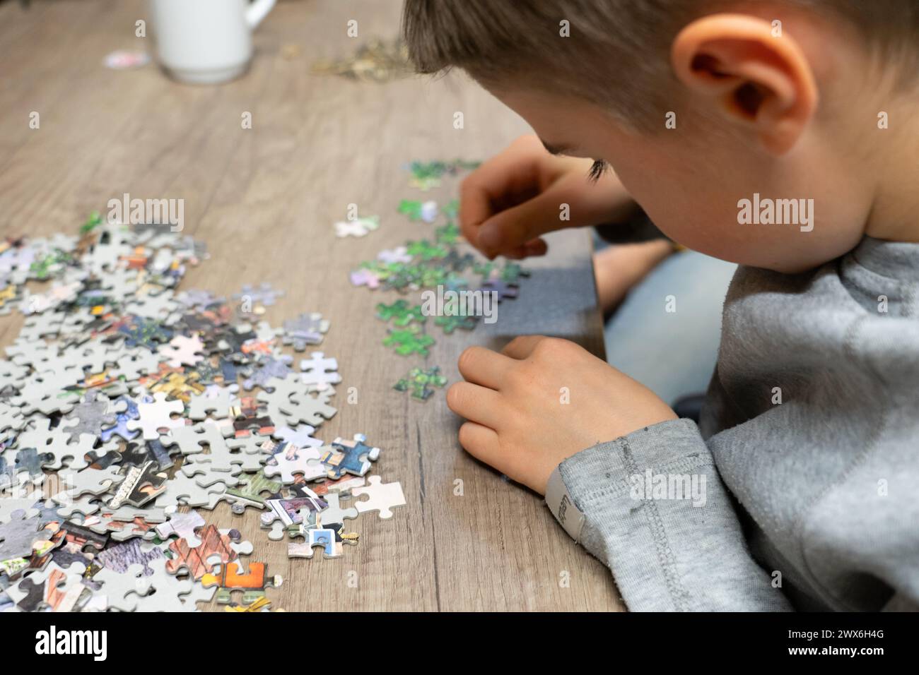 Concentrated boy doing a puzzle Stock Photo - Alamy
