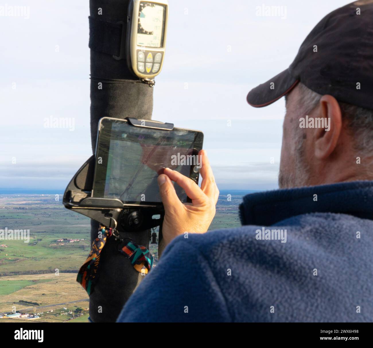 Hot air balloon pilot looking at gps from the air Stock Photo - Alamy