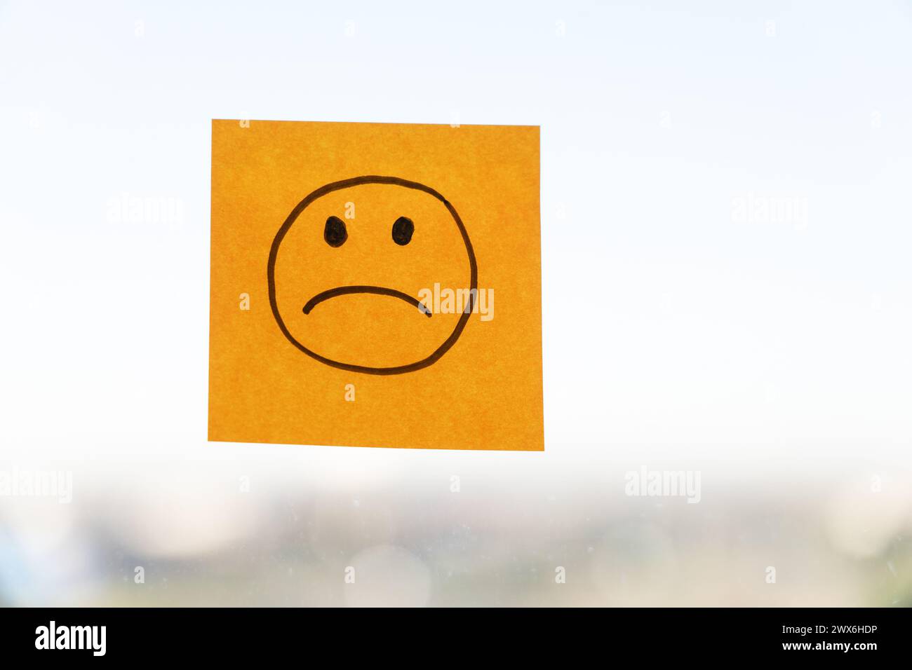 Sad emoticon drawn on a post it Stock Photo - Alamy