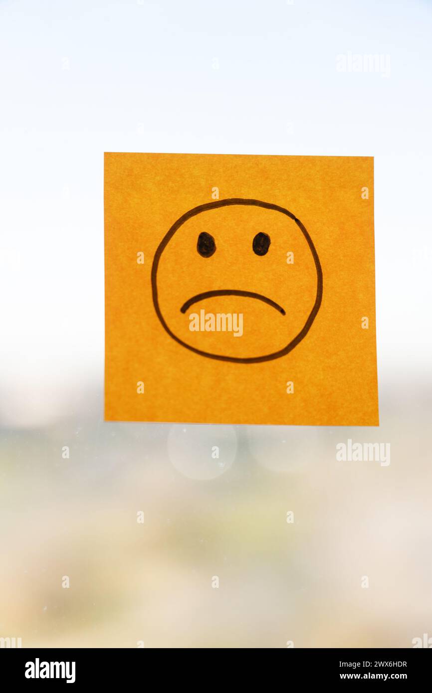 Sad face on a post it Stock Photo - Alamy