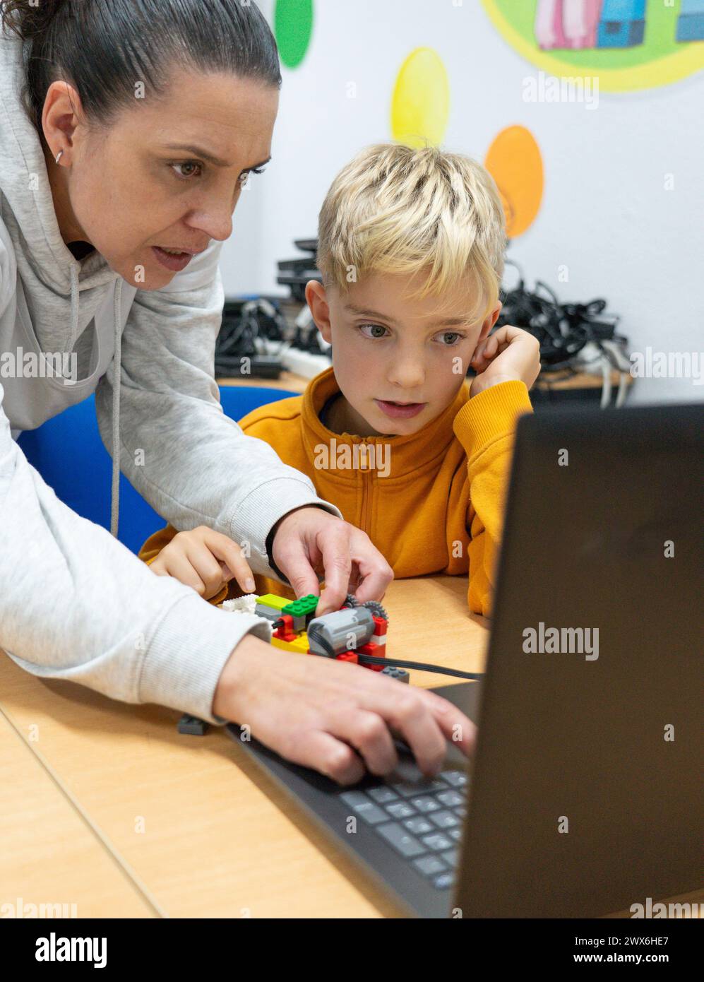 Robotics teacher teaching a child at school Stock Photo - Alamy