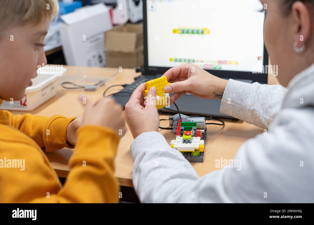 Robotics teacher teaching a child to build and program a robot Stock ...