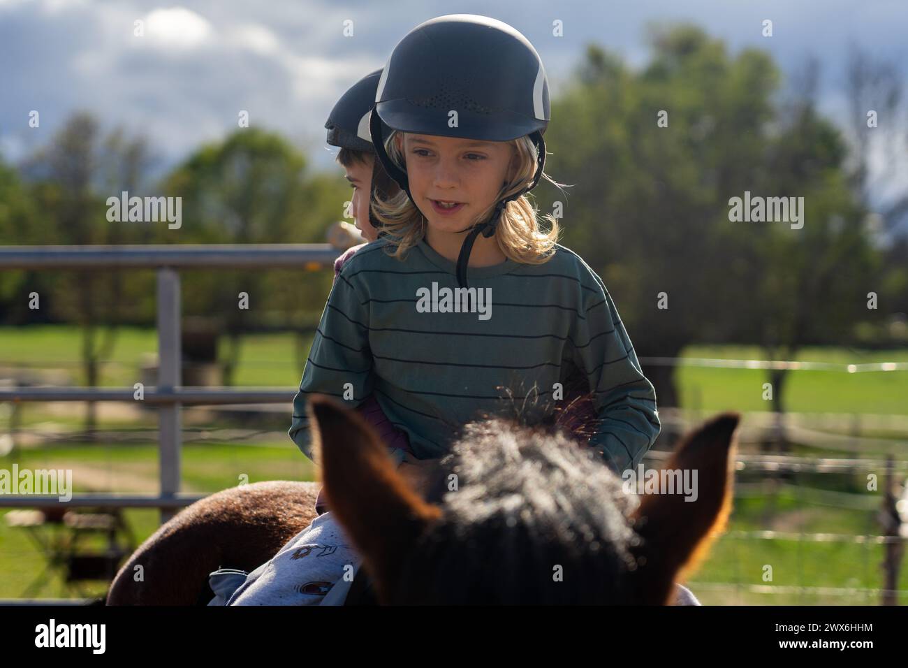 Two children riding horses together on a farm Stock Photo - Alamy