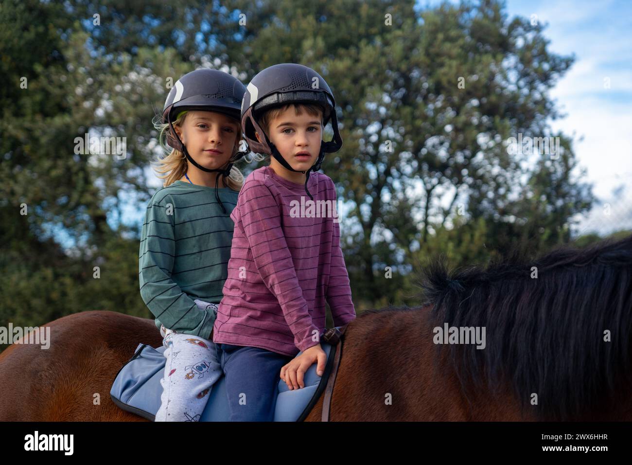 Two children riding a horse together Stock Photo - Alamy