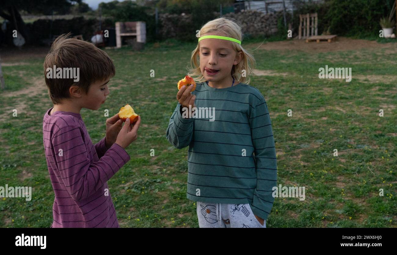 Children eating apple outdoors Stock Photo - Alamy