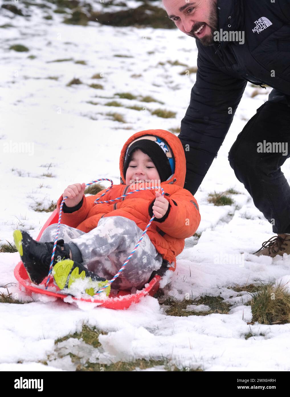 Jack Campbell pushes his son Harvey on a sledge in the snow on Dartmoor ...