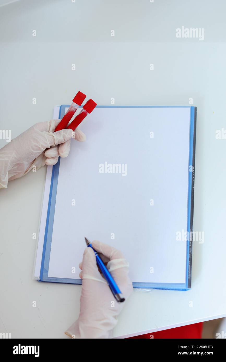 female doctors hand hold test tubes with blood, and write on a white ...