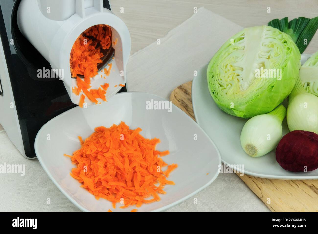 Carrot, beets, onion and cabbage in a vegetable cutter on kitchen table ...