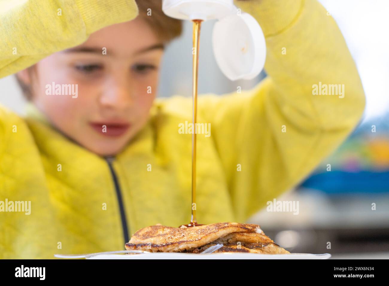 Boy pouring syrup on some pancakes Stock Photo - Alamy