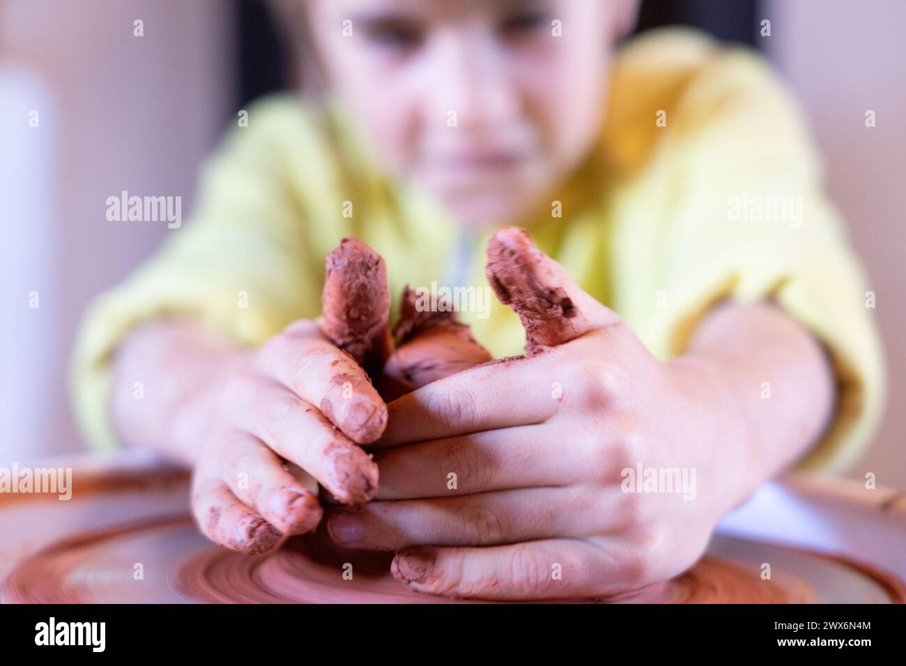 Child molding clay on a potter's wheel Stock Photo - Alamy