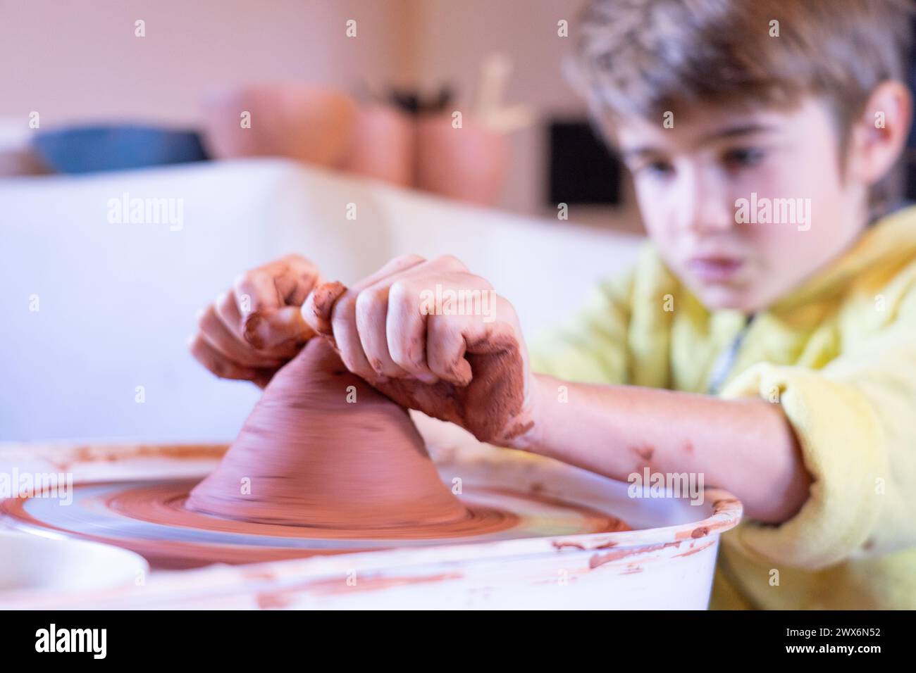 Concentrated boy making a piece of pottery on a potter's wheel Stock ...