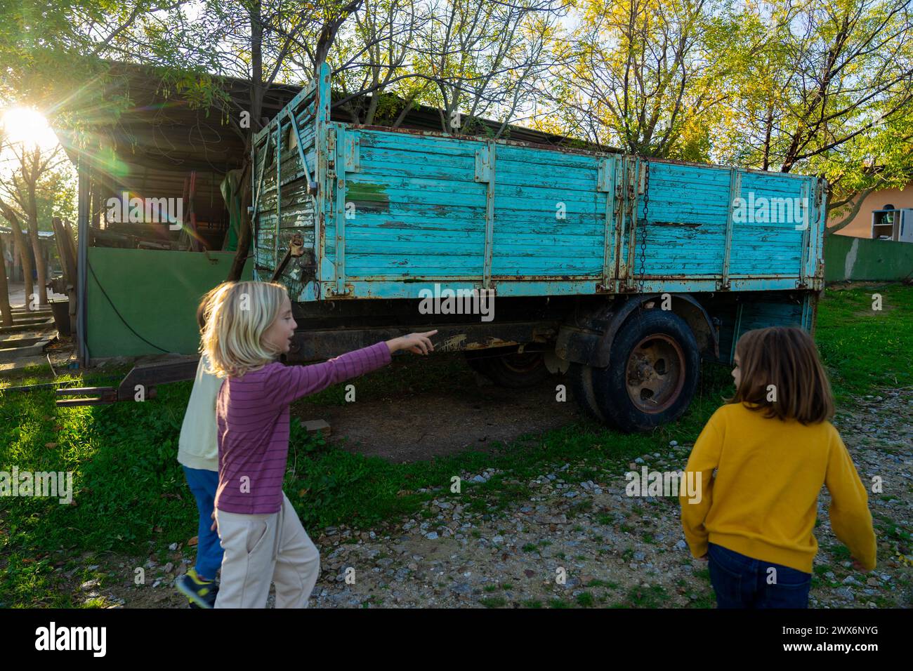 Three children playing on a school farm Stock Photo - Alamy