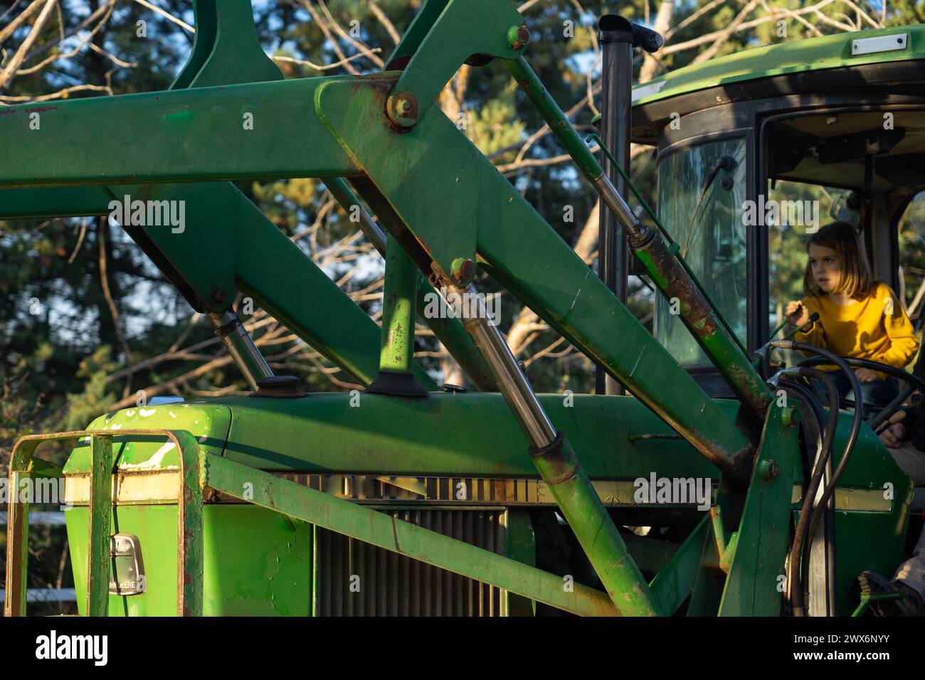 Boy riding a tractor on a farm Stock Photo - Alamy