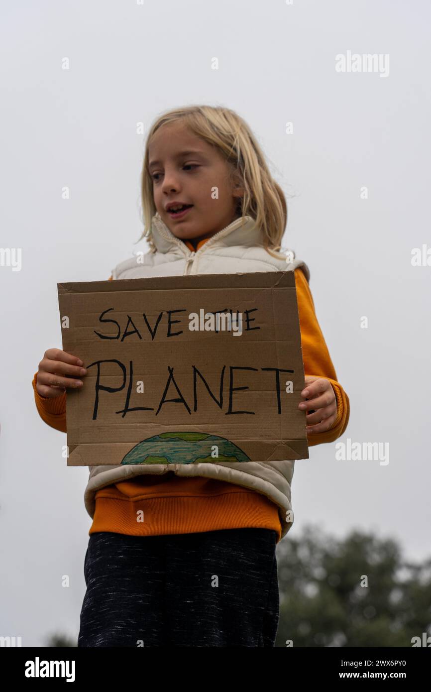 Boy with a "Save the planet" sign Stock Photo - Alamy