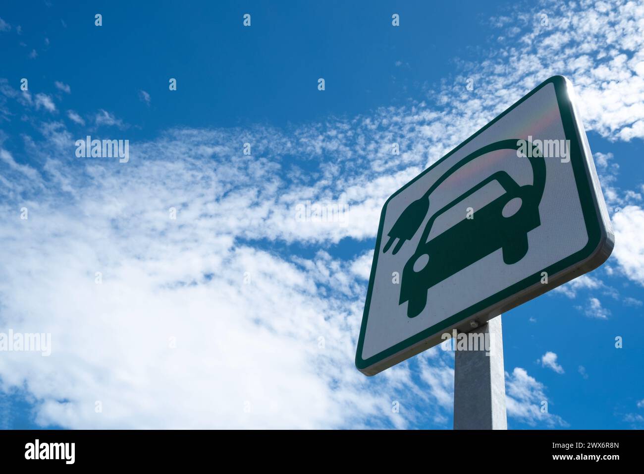 Low angle view of an electric car recharging point road sign, against a ...