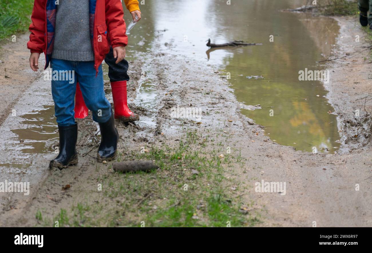 Children in wellies walking through a muddy puddle Stock Photo - Alamy