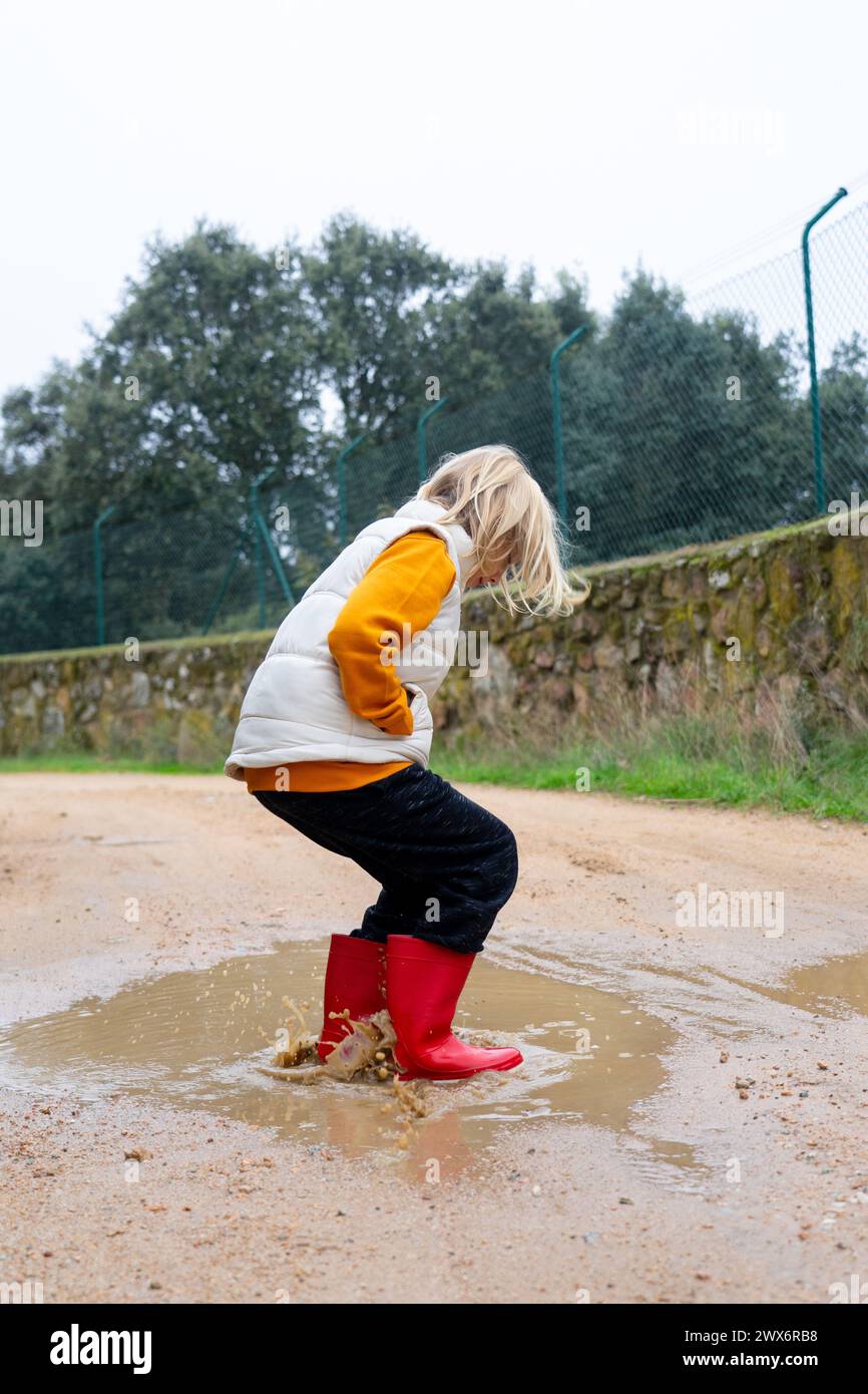 Boy jumping in puddle hi-res stock photography and images - Alamy