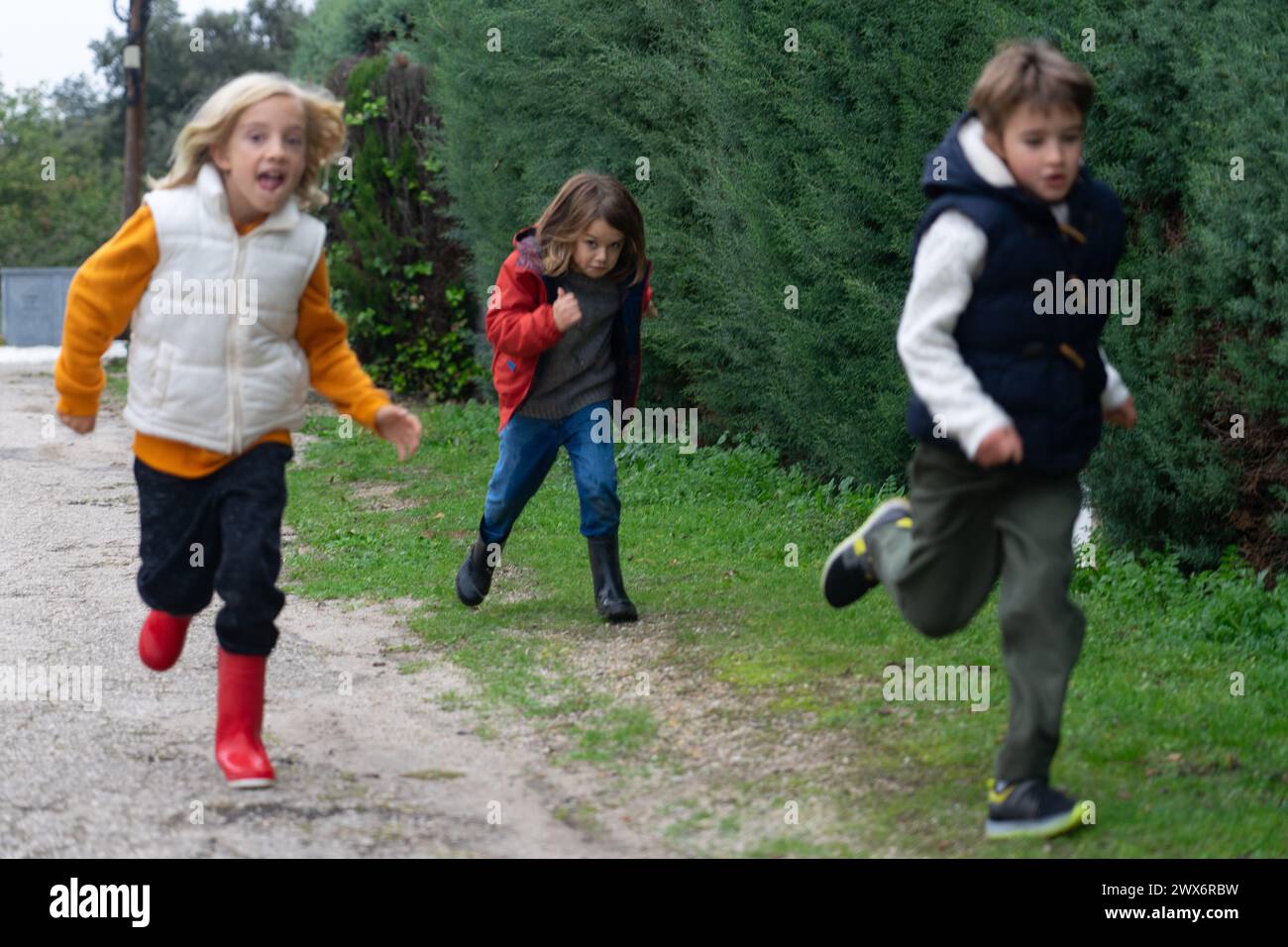 Three children running down the street Stock Photo - Alamy