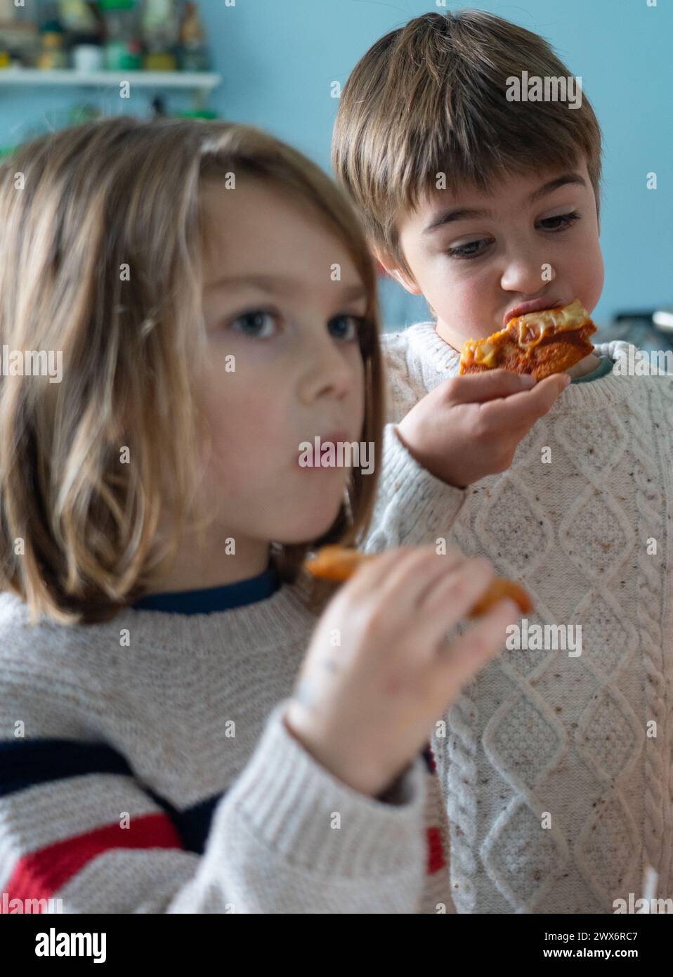 Two children eating homemade pizza together Stock Photo - Alamy
