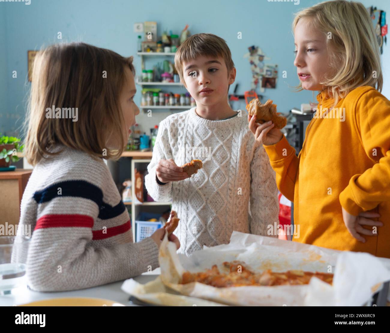 children eating pizza together in a kitchen Stock Photo - Alamy