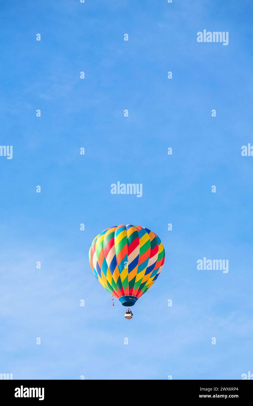 A vibrant hot air balloon drifts gracefully against the backdrop of a ...