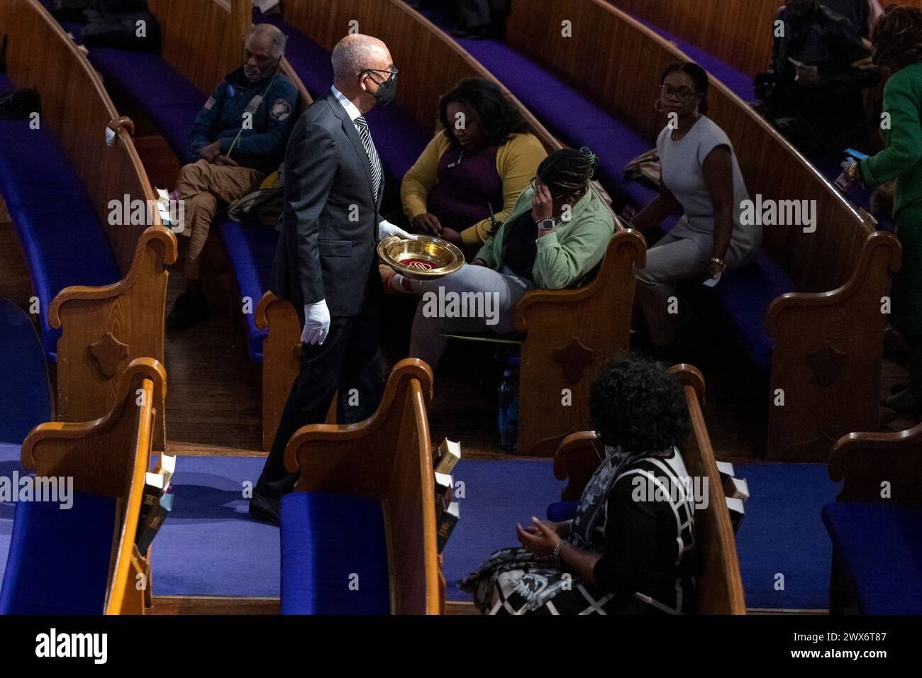 A donation plate is passed during Palm Sunday services at the ...