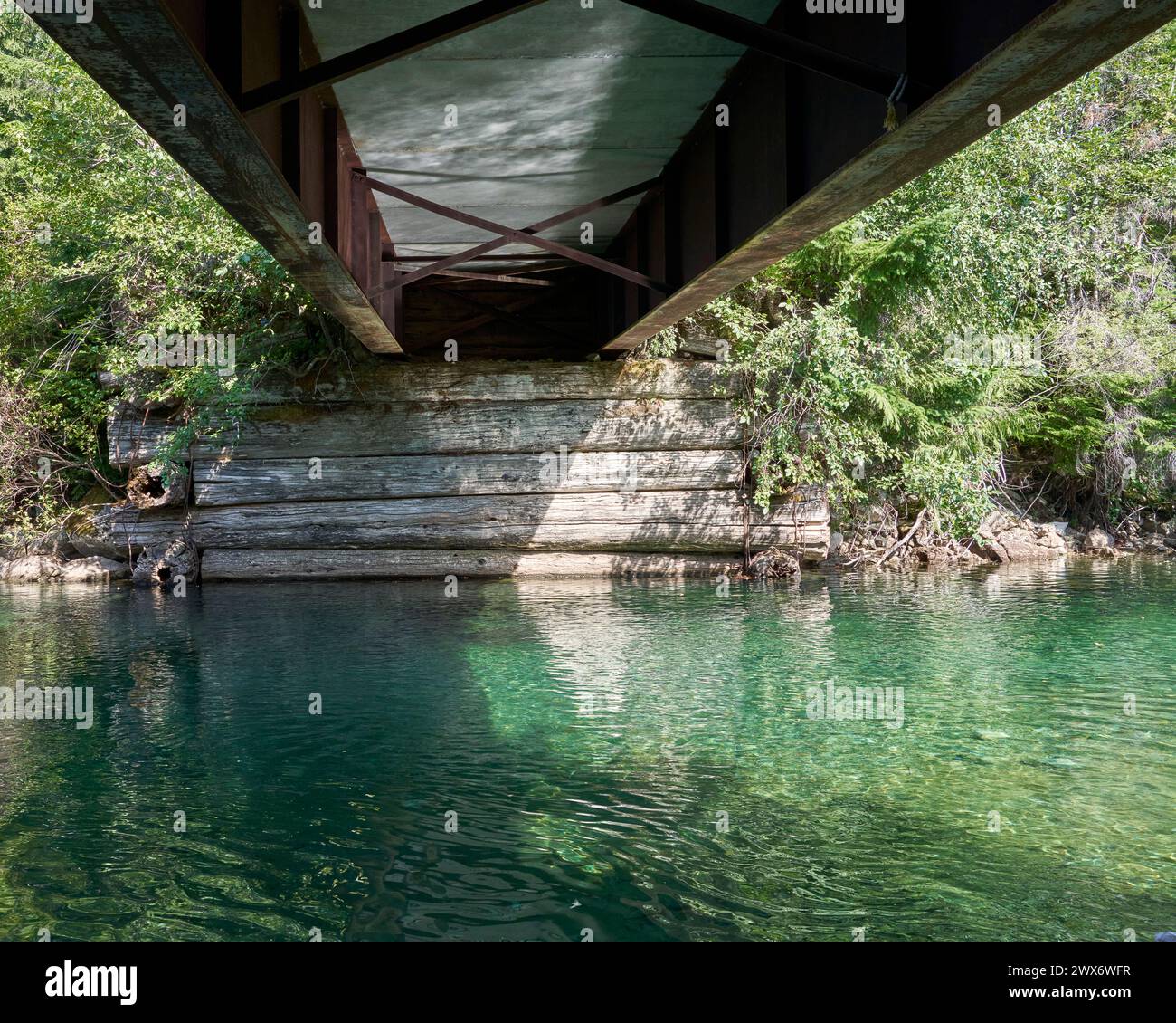 The underside of a remote wooden logging bridge reflected in the ...