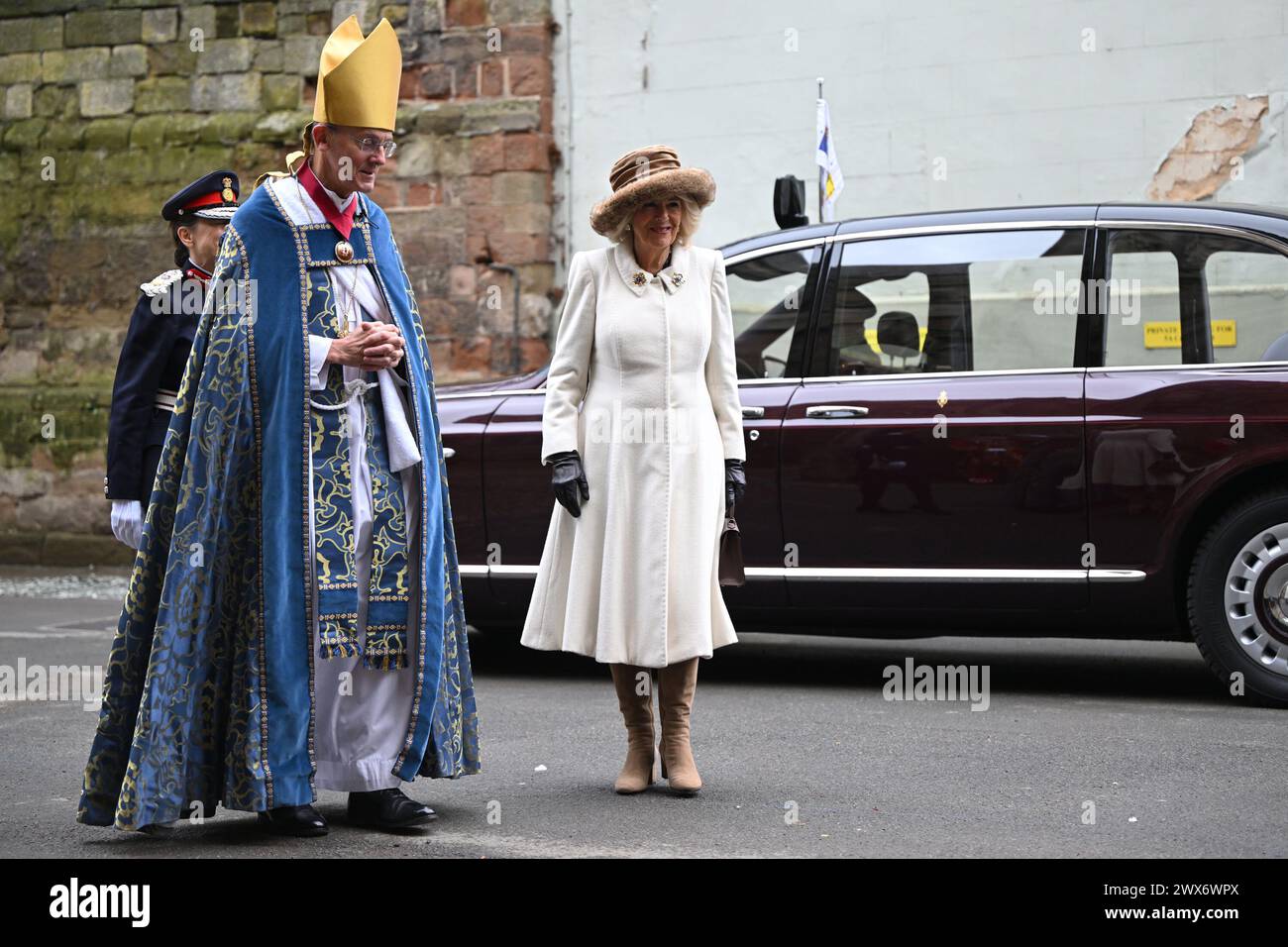 Queen Camilla walks with the Bishop of Worcester, John Inge as she ...