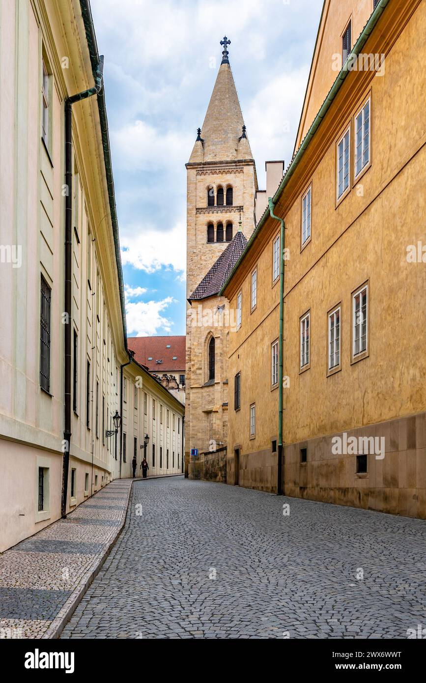 A quiet, cobbled street of Prague Castle flanked by historic buildings ...