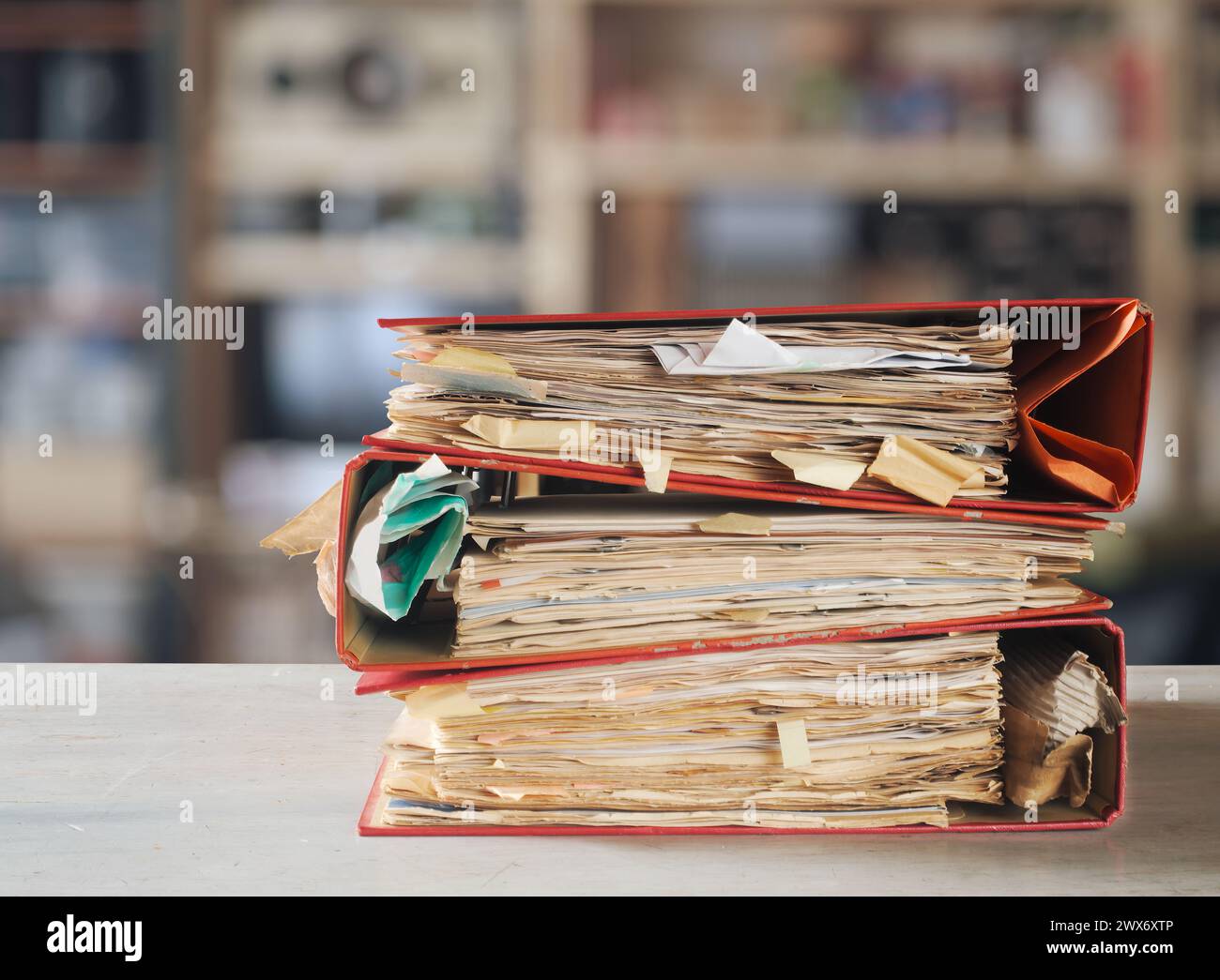 stack of dusty messy file folders with narrow depth of field, blurred ...