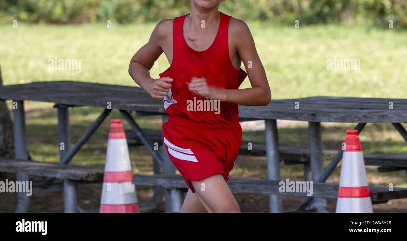 Close up of one Cross country runner passing a picnic table while ...