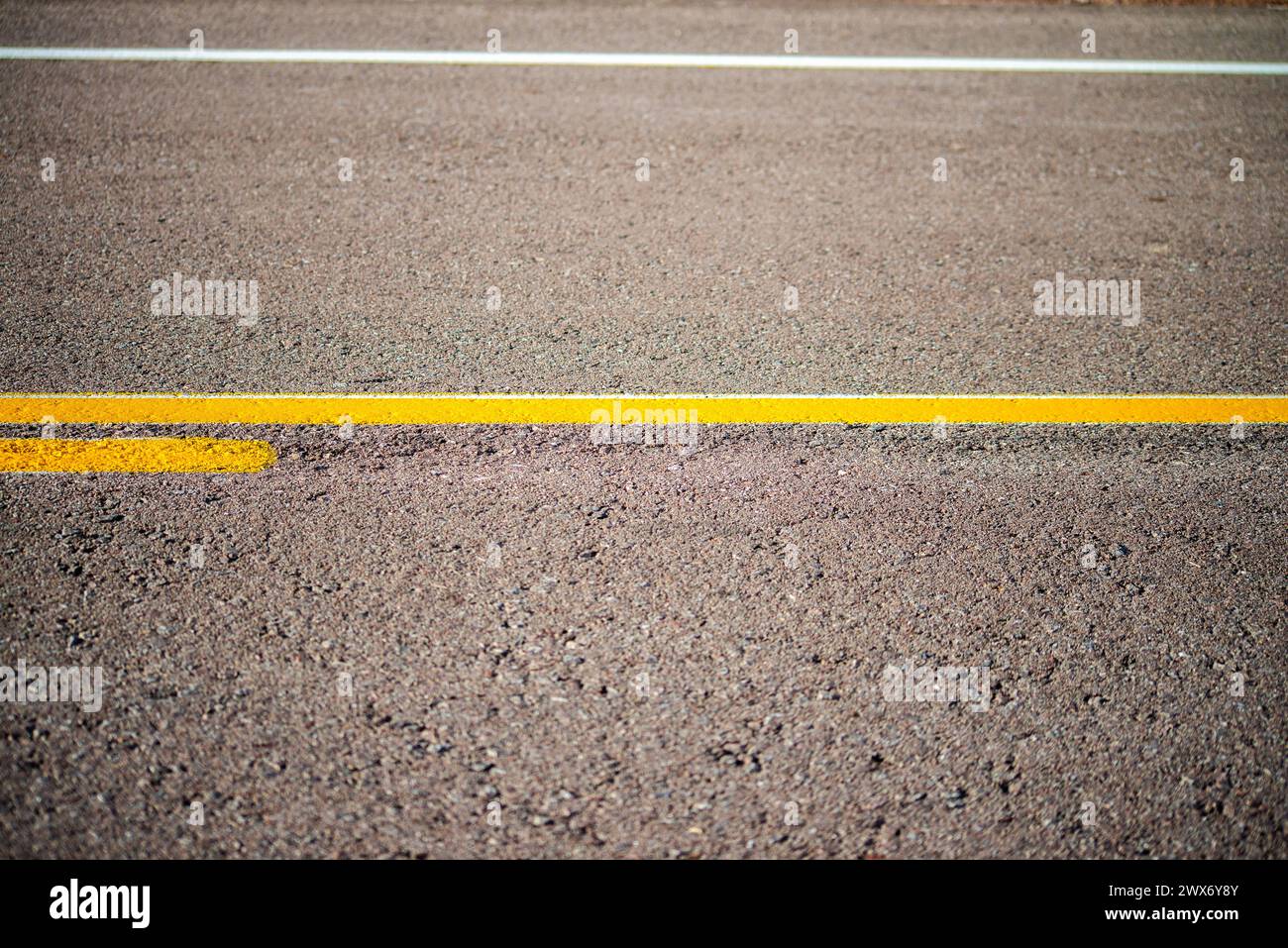 An asphalt road adorned with crisp white stripes, guiding urban ...