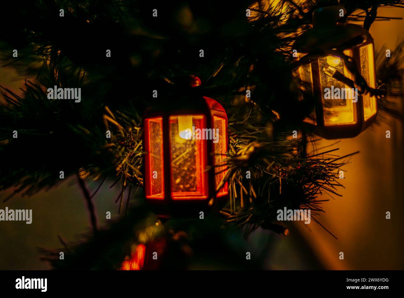 Glowing street lamp-shaped lanterns adorn the Christmas tree, casting ...