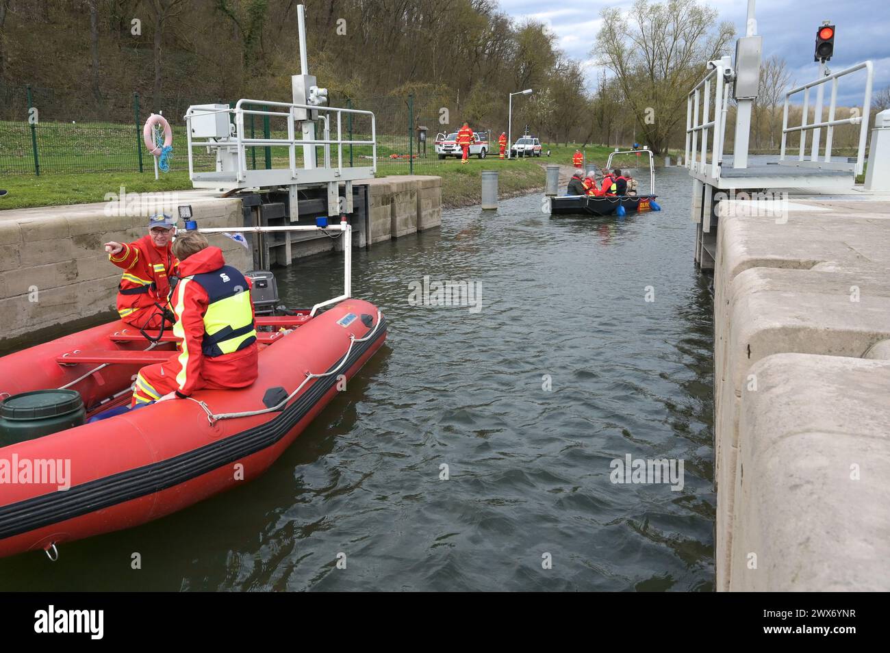 28 March 2024, Saxony-Anhalt, Tröbsdorf: Boats from the DLRG enter the ...