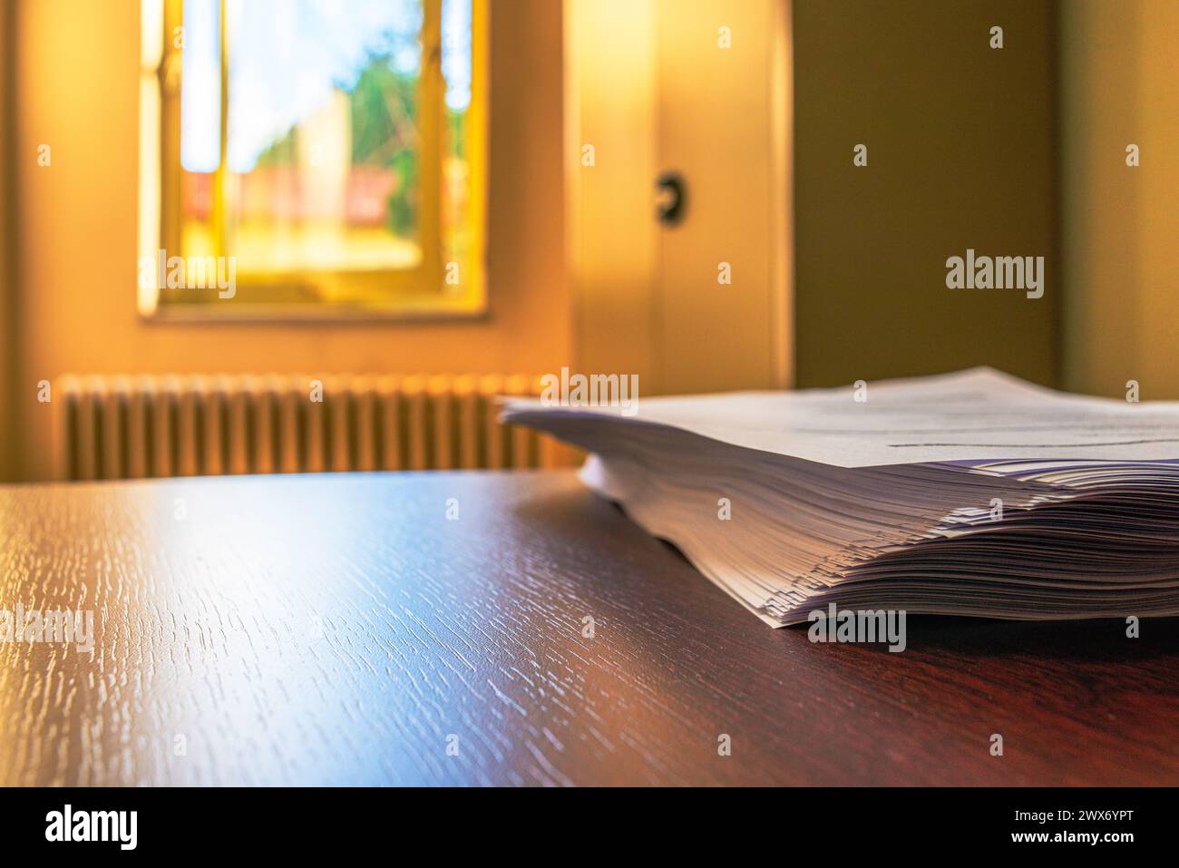 A pristine desk adorned with neatly stacked white A4 papers, creating ...