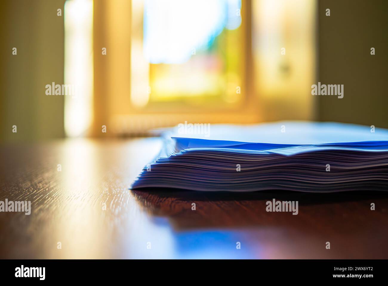 A pristine desk adorned with neatly stacked white A4 papers, creating ...