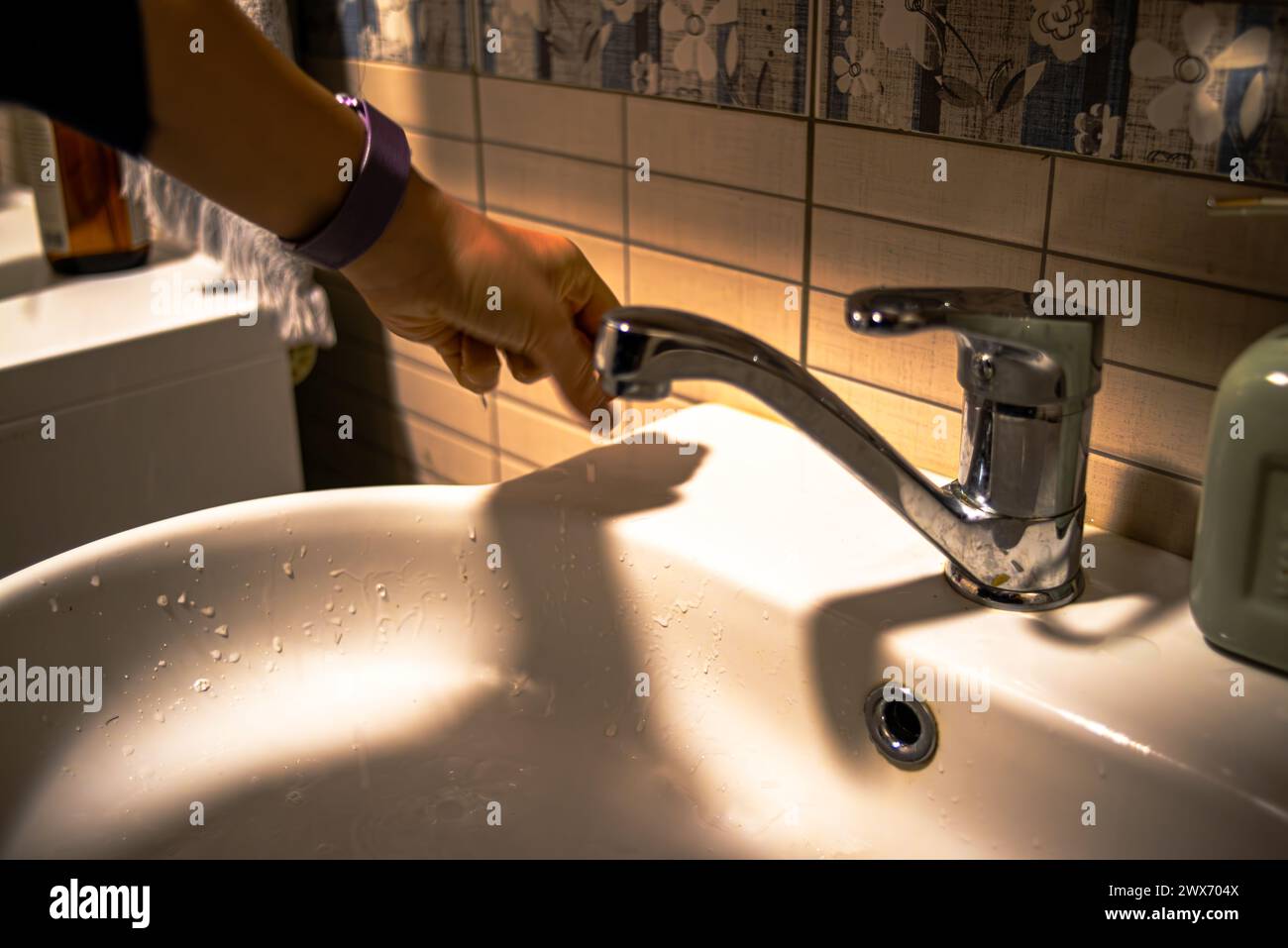 A woman diligently washes her hands, taking precautions against ...