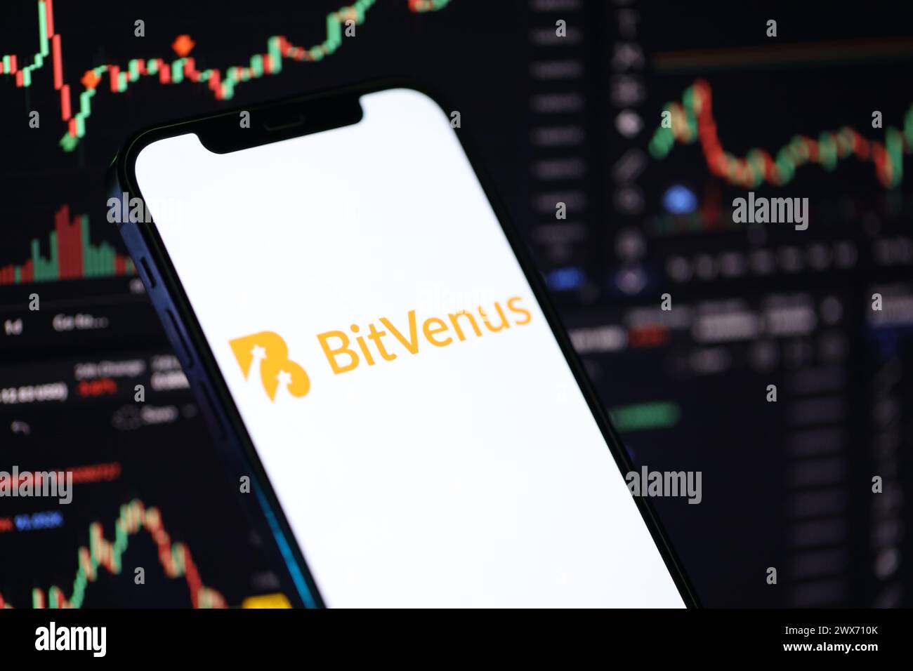 KYIV, UKRAINE - MARCH 15, 2024 Bitvenus logo on iPhone display screen and crypto currency value ...