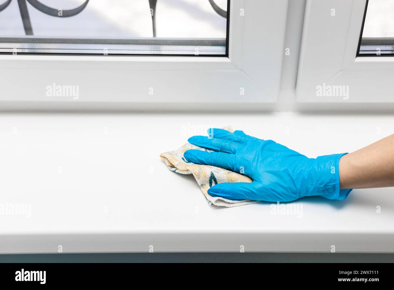 housewife wearing gloves wipes a plastic window sill Stock Photo - Alamy