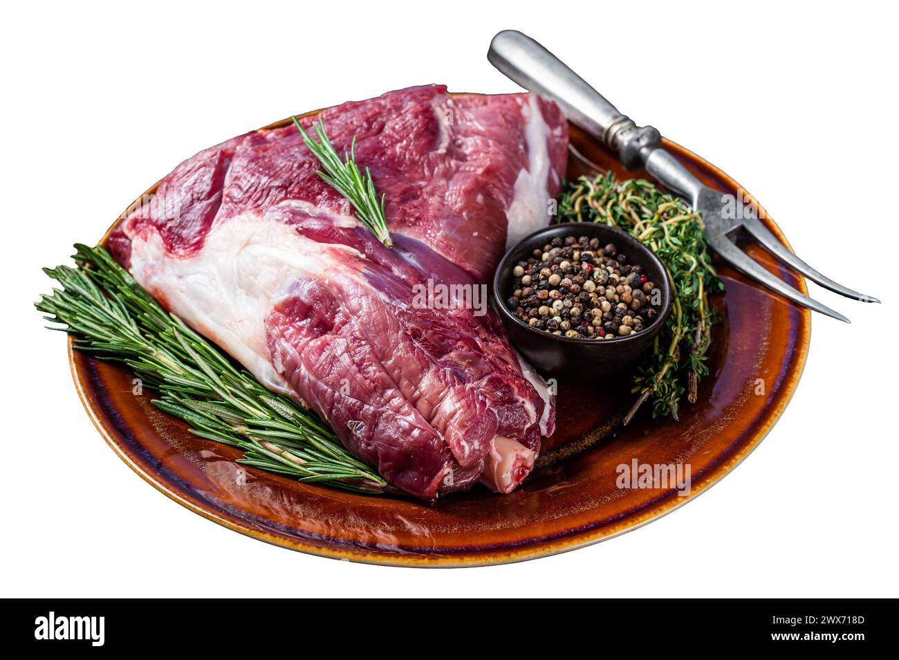 Uncooked Raw goat thigh or leg with rosemary and thyme in rustic plate ...