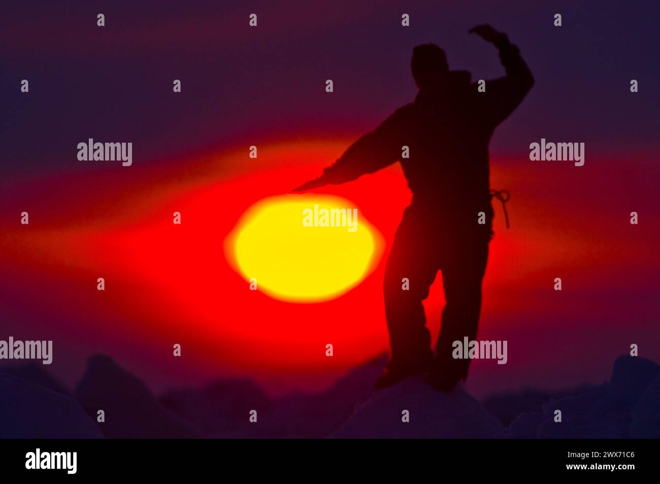 Inupiaq man hold his hand under the midnight sun in the Chukchi Sea ...