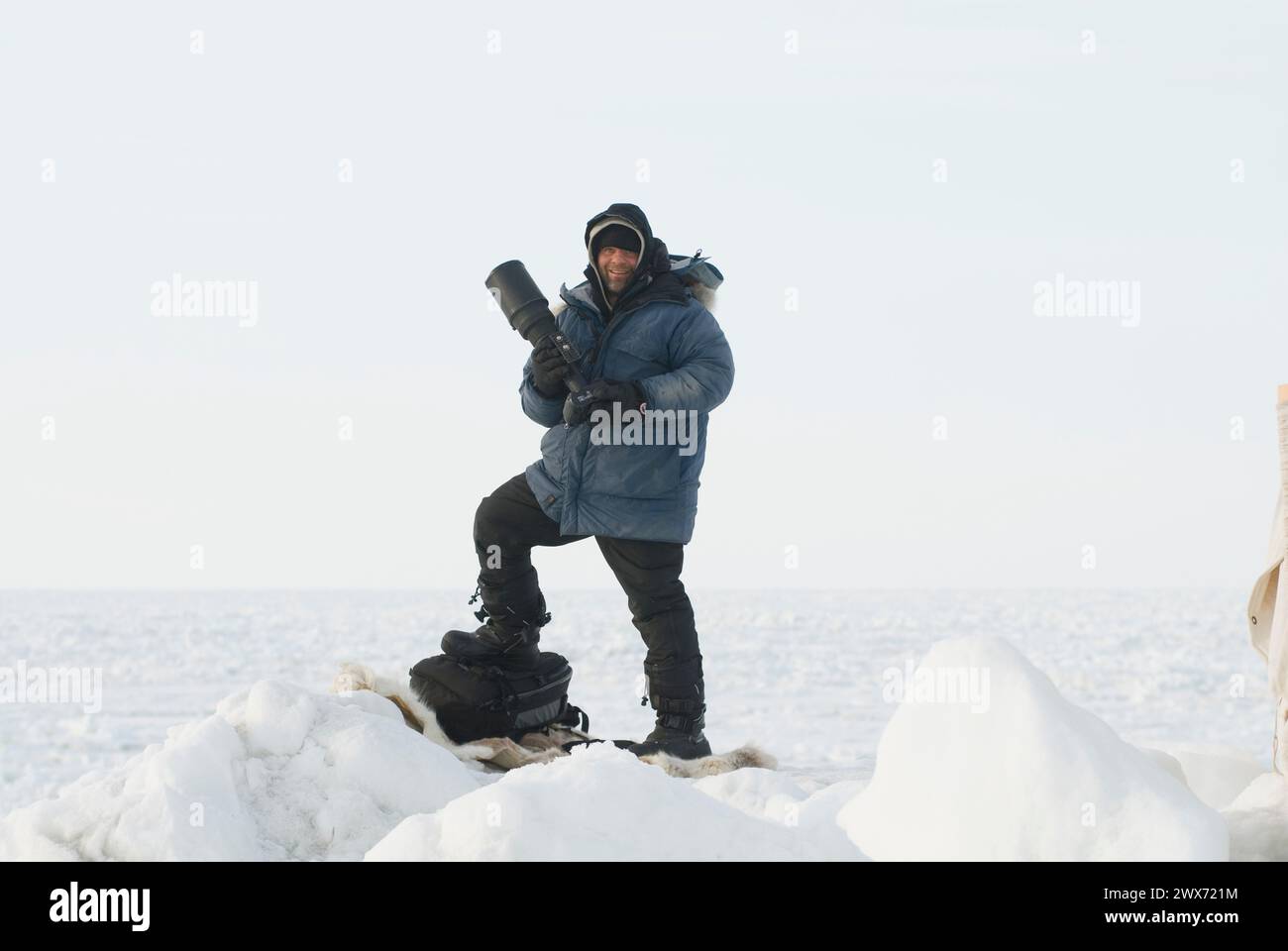 Photographer Steven Kazlowski with camera, tripod at the edge of an ...